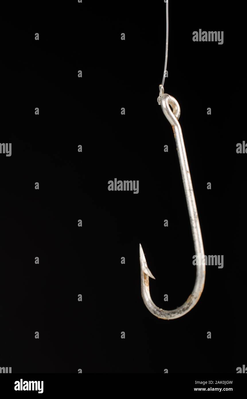 Fishing hook on black background, a concept Stock Photo - Alamy