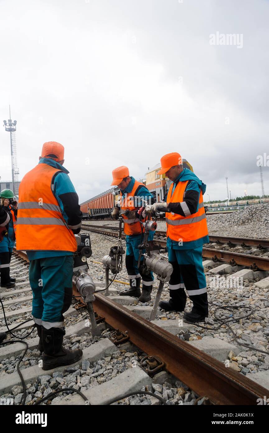 Railway Workers repairing rails in rainy day Stock Photo - Alamy