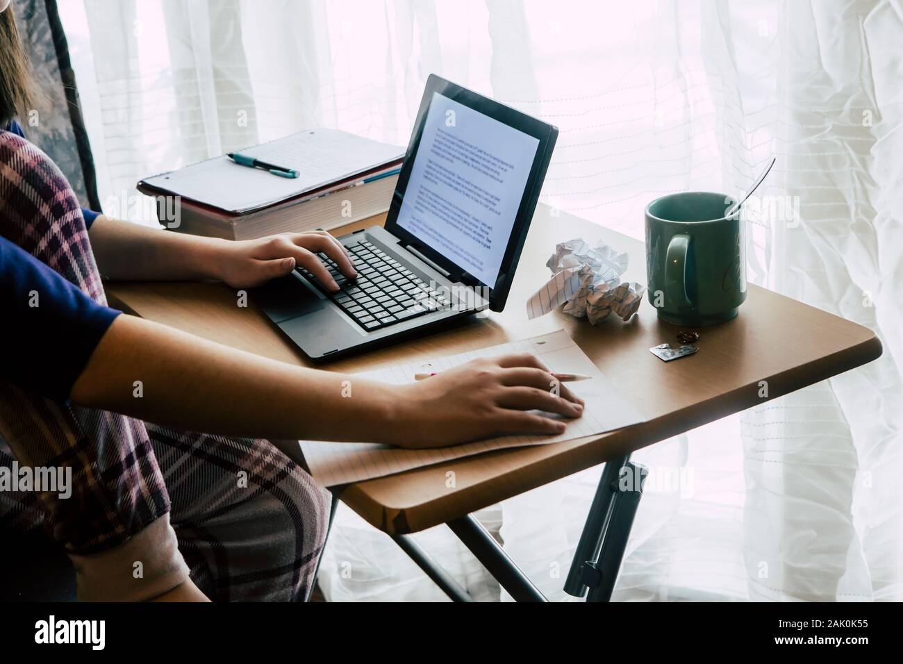 A lifestyle photo of a girl using the notebook computer at home to do ...