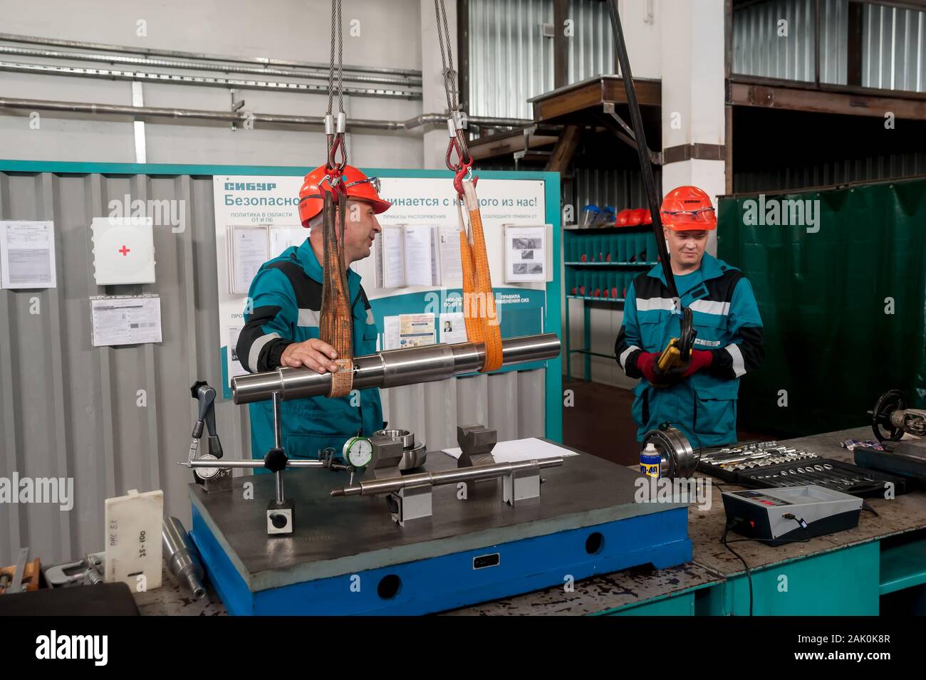 Mechanics transfer detail to workbench by crane Stock Photo - Alamy
