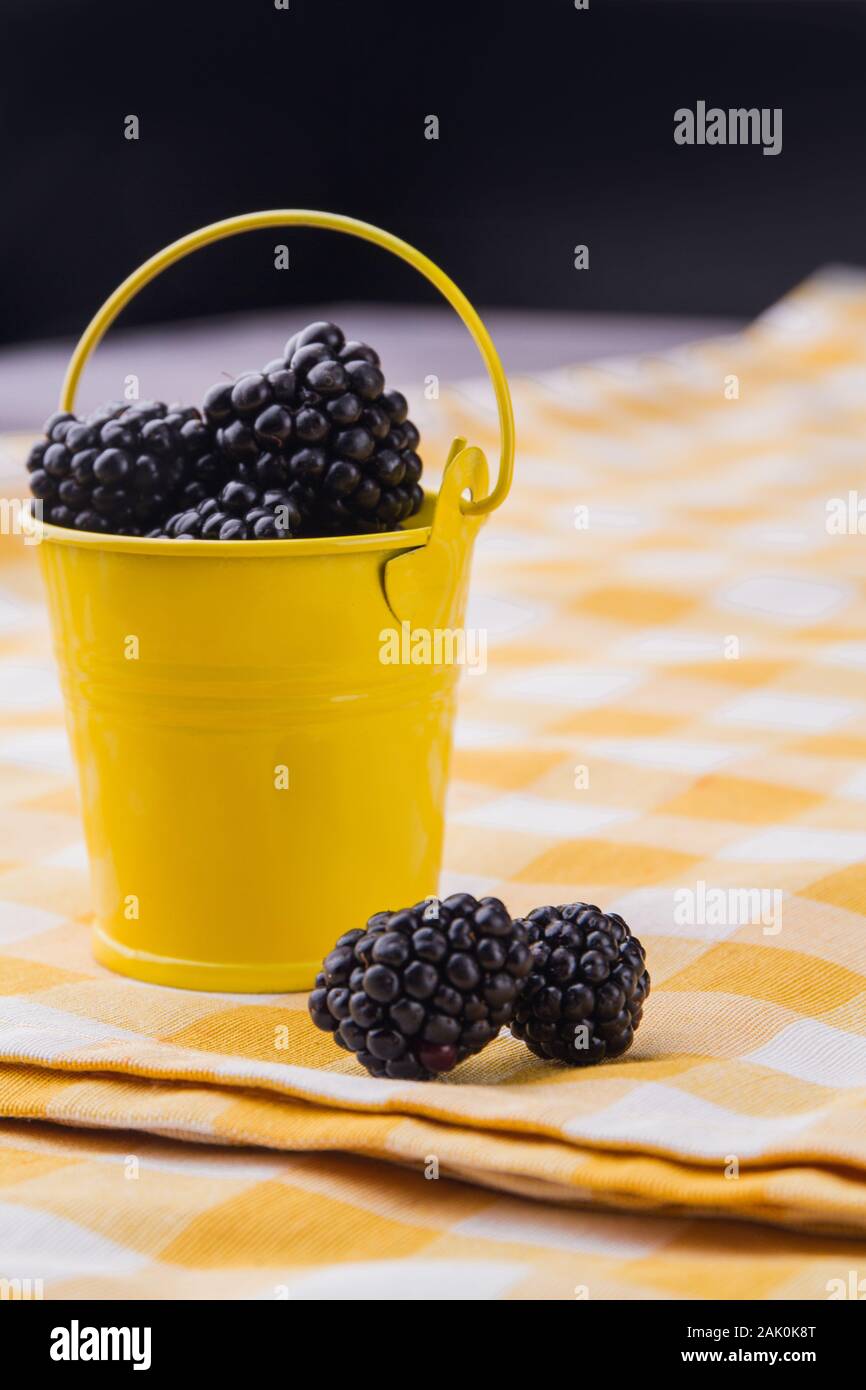 Small yellow bucket full of blackberries Stock Photo - Alamy