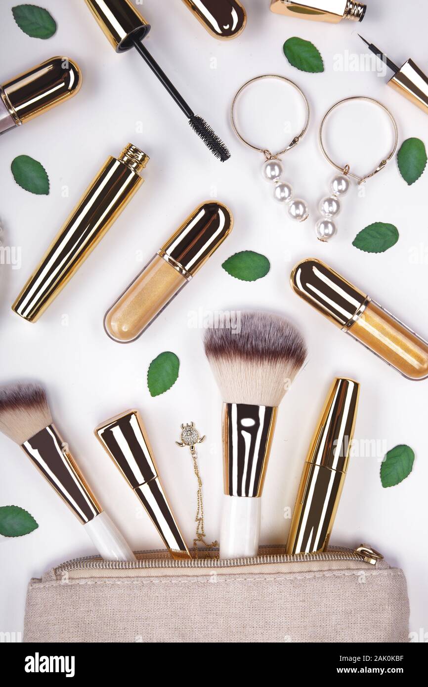 Set of brushes and cosmetic products in a cosmetic bag on a white ...