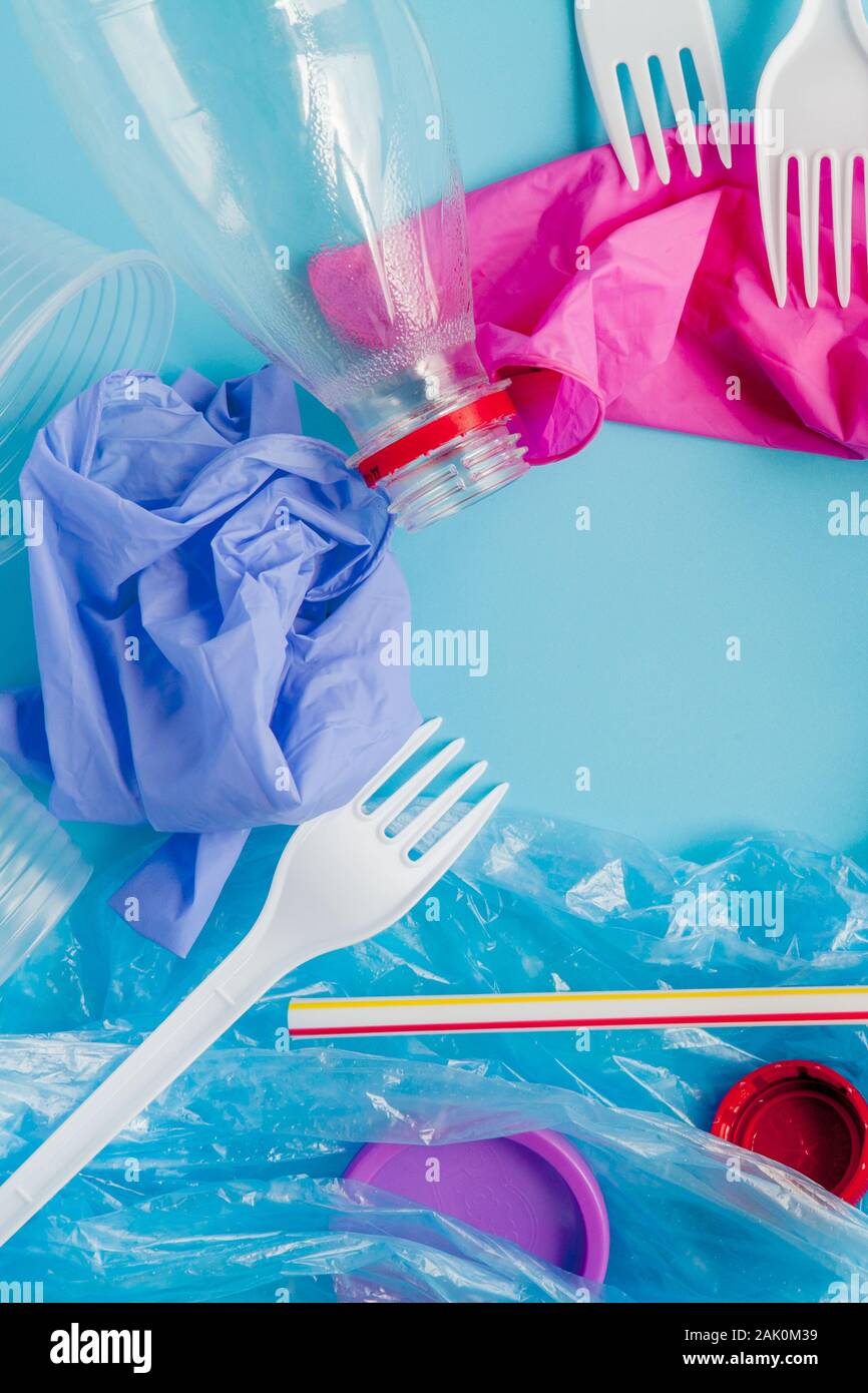 Top view of various kinds of disposable plastic waste on blue ...