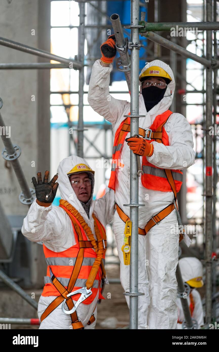 Workers in white protective uniform fixing pipes Stock Photo - Alamy