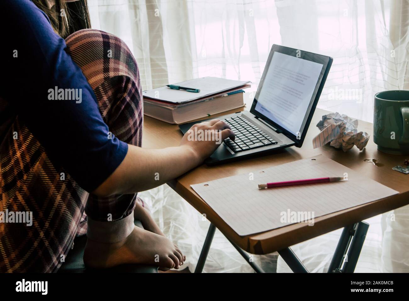 A lifestyle photo of a girl using the notebook computer at home to do ...