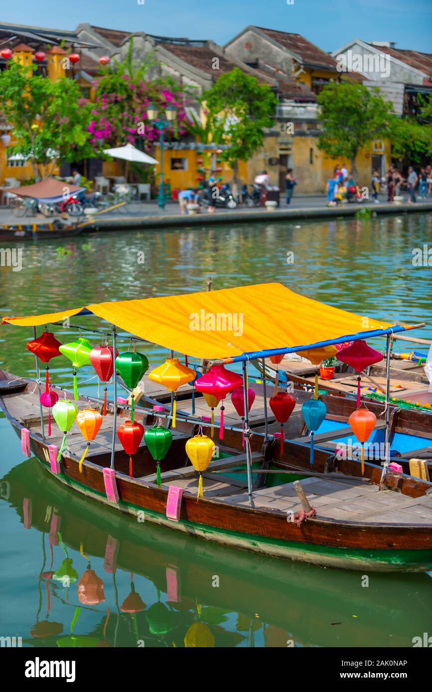 Traditional wooden Vietnamese boat decorated with lanterns along the ...