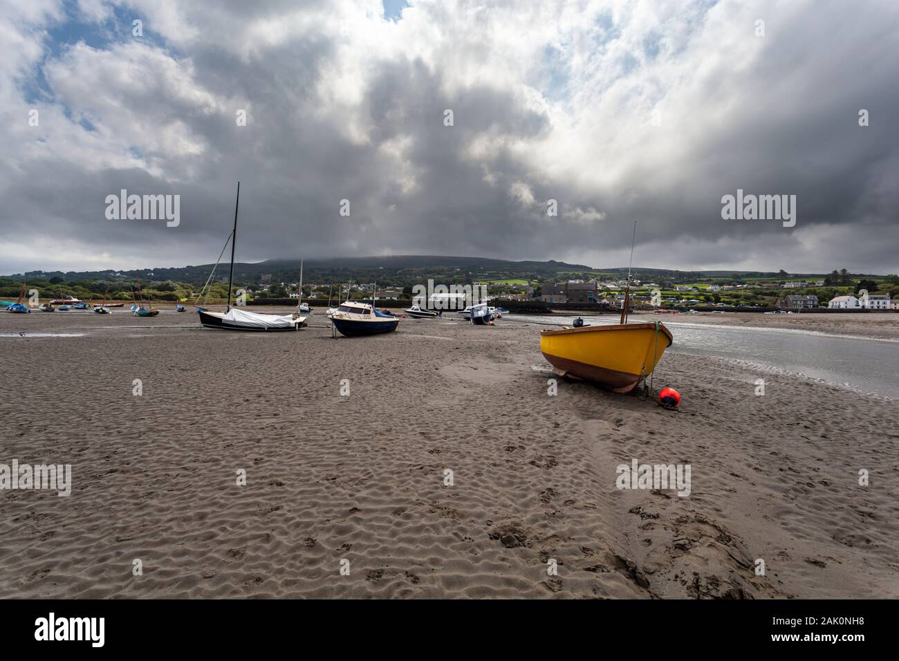 Boats are sitting on the sand in the Nervern estuary, while clouds ...