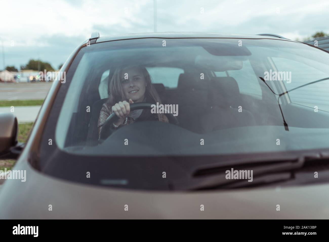 woman in car, sitting behind the wheel of a car, happy smile, right ...