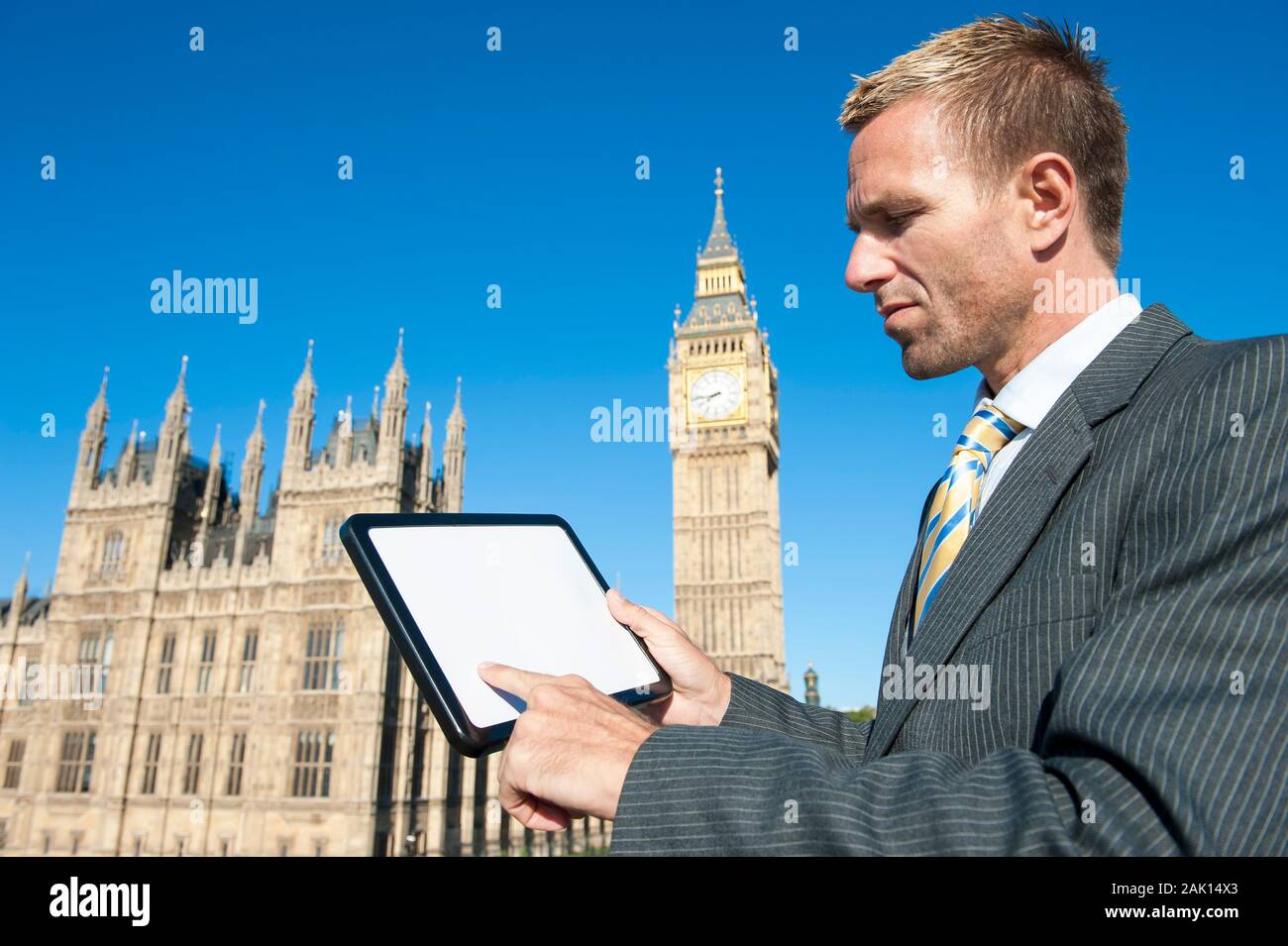 British politician using tablet computer in front of the Houses of ...