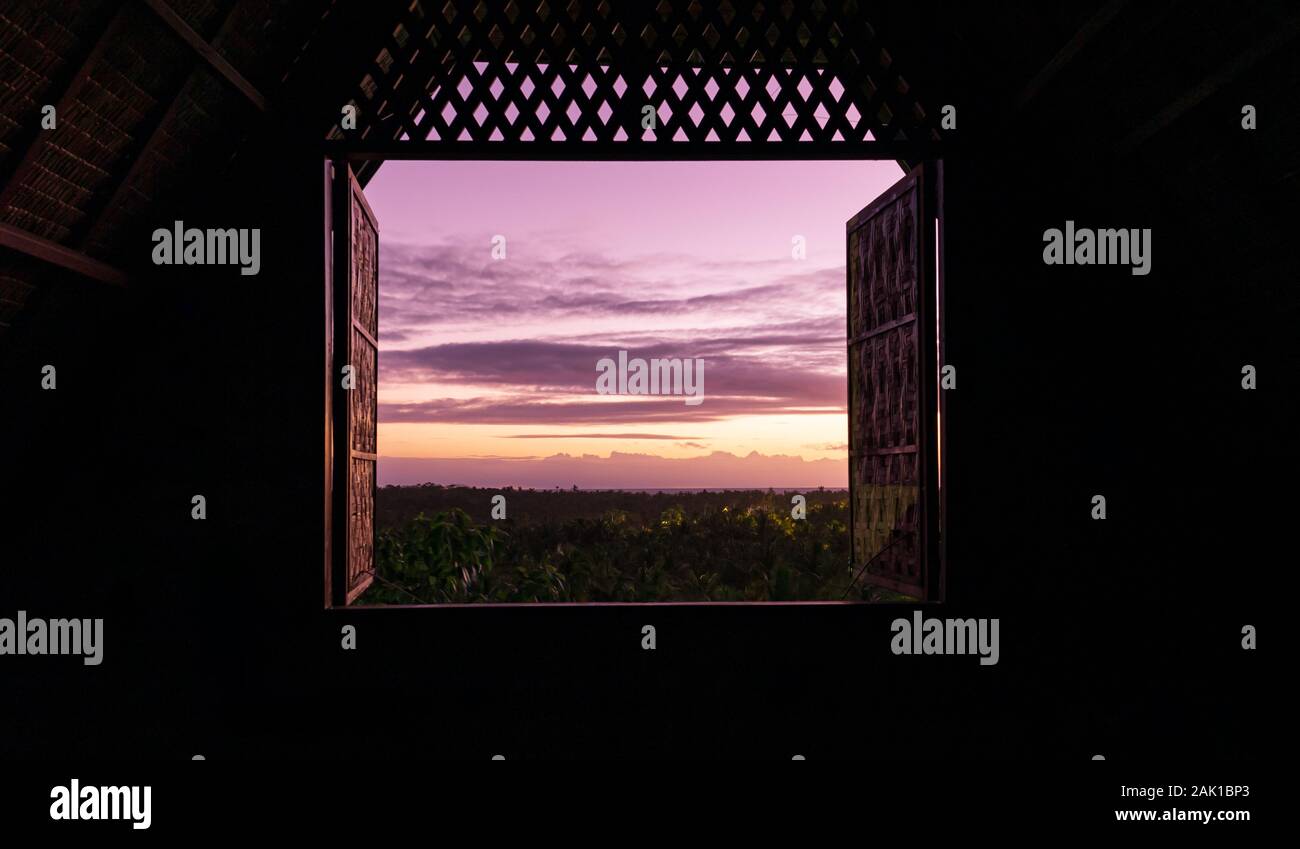 Window opens from dark room to beautiful sunrise view over jungle Stock ...