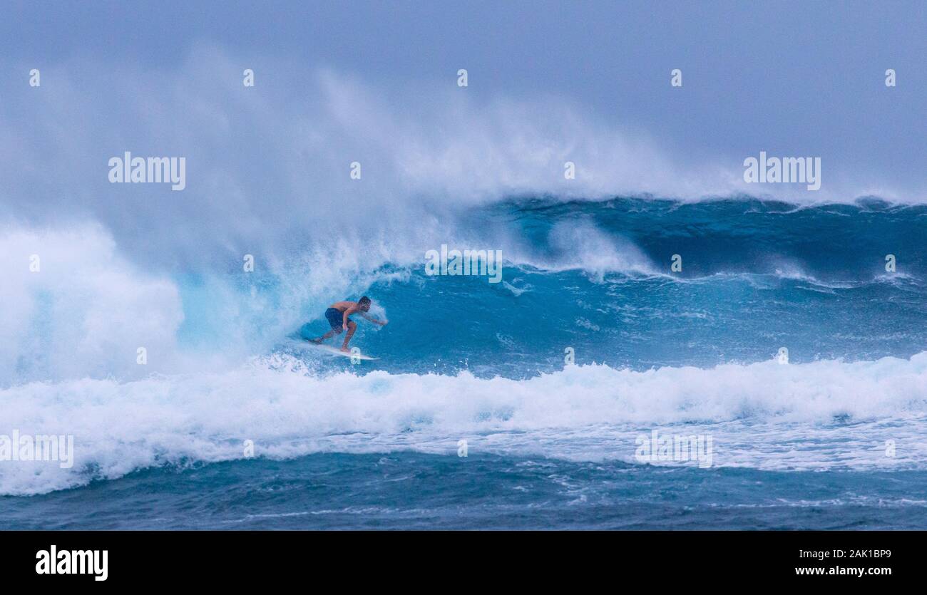 Male surfer on edge of barrel as large wave closes in from behind Stock ...