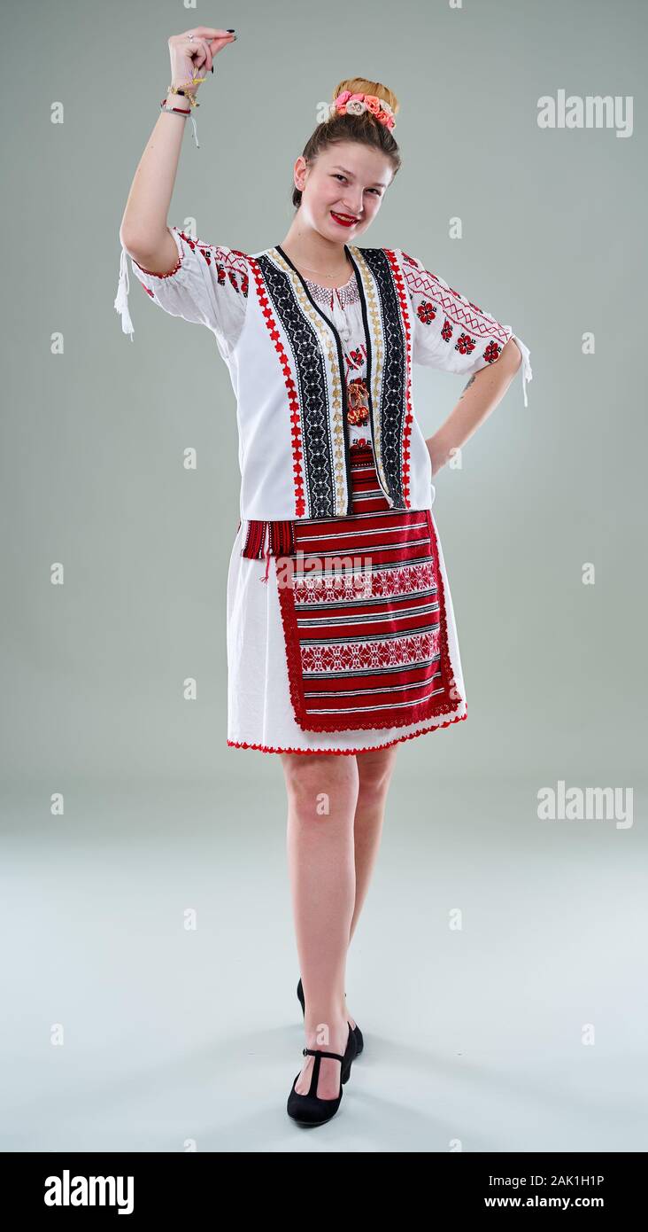 Young Romanian woman in popular costume, dancing on traditional music ...