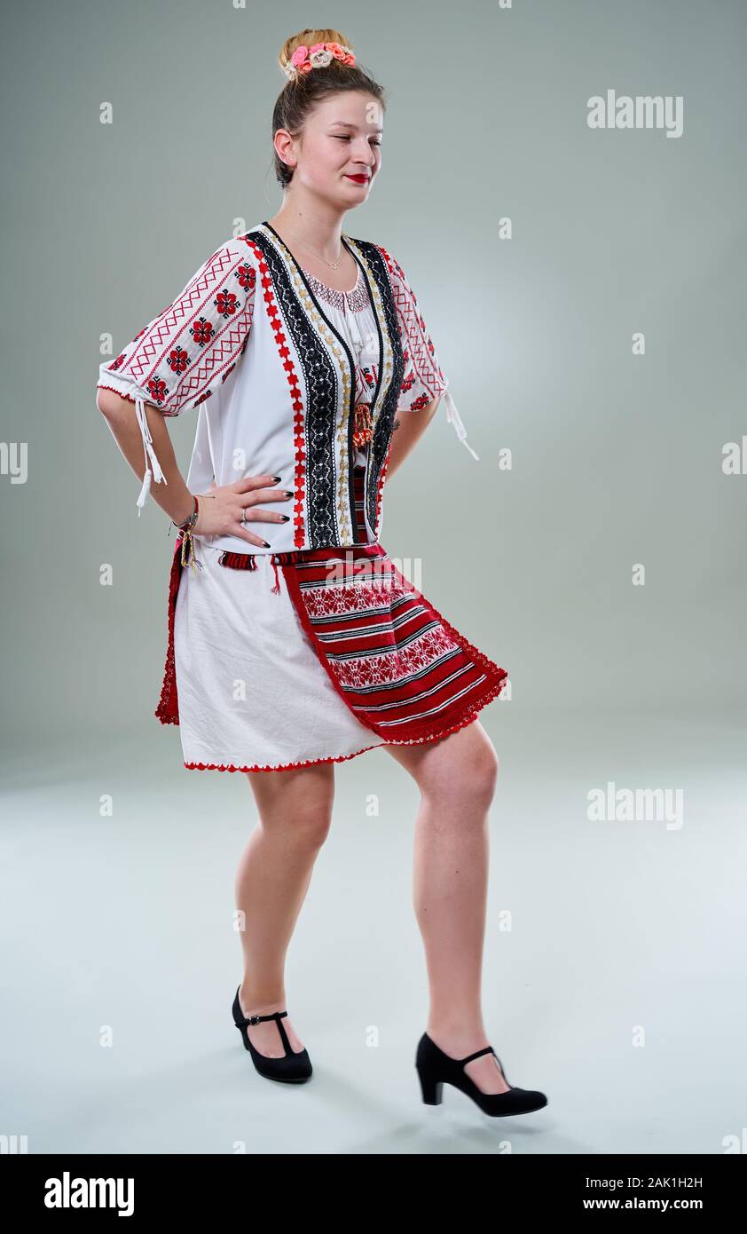 Young Romanian woman in popular costume, dancing on traditional music ...