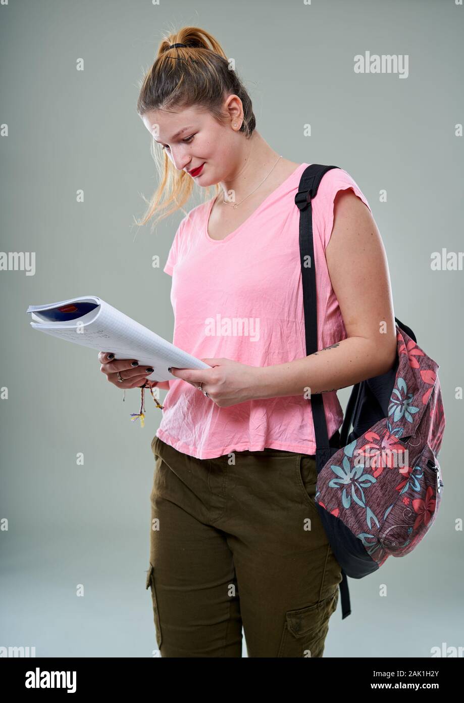 Young student girl with school bag studio shot isolated on gray Stock ...