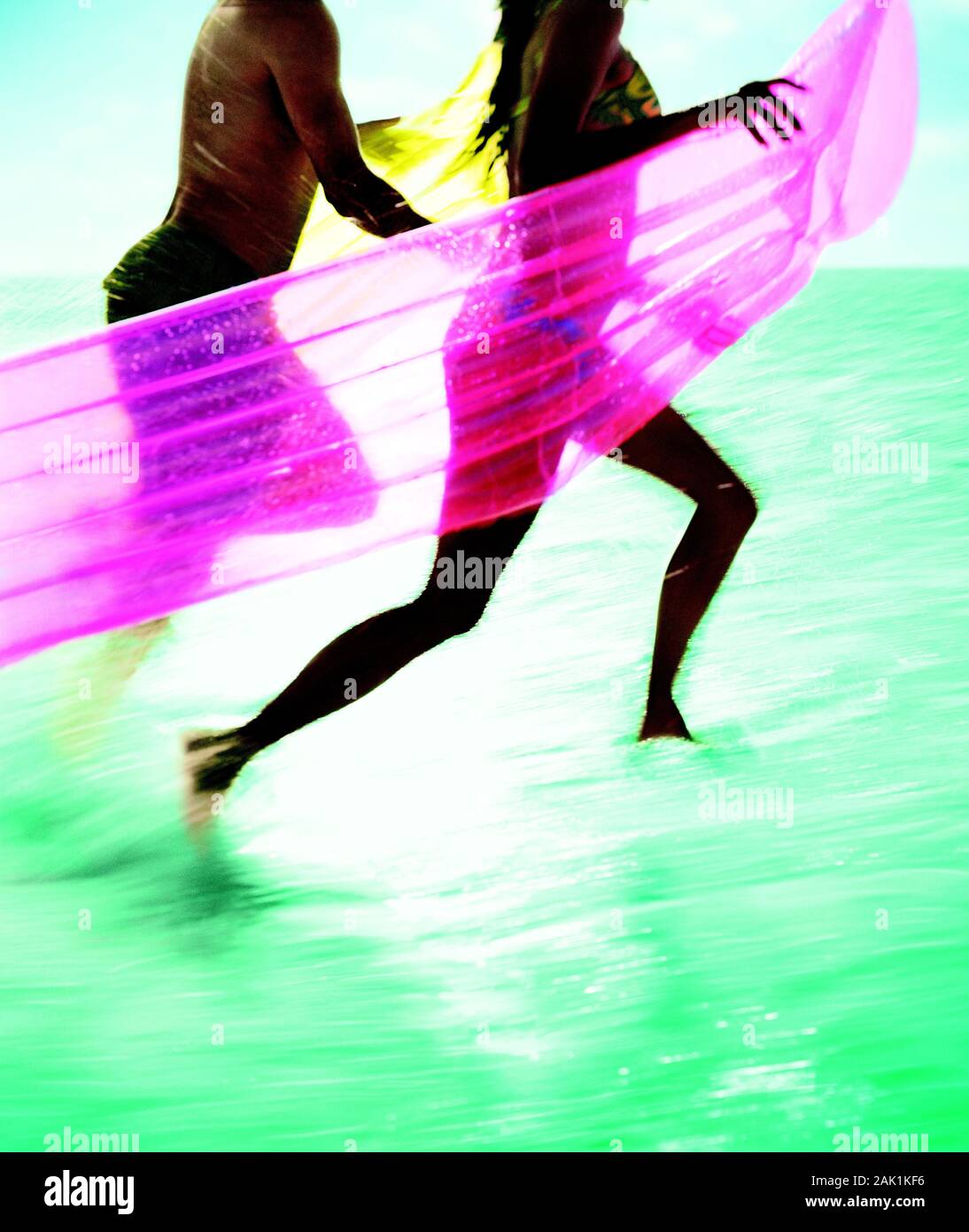 Couple running with rafts in the surf Stock Photo - Alamy
