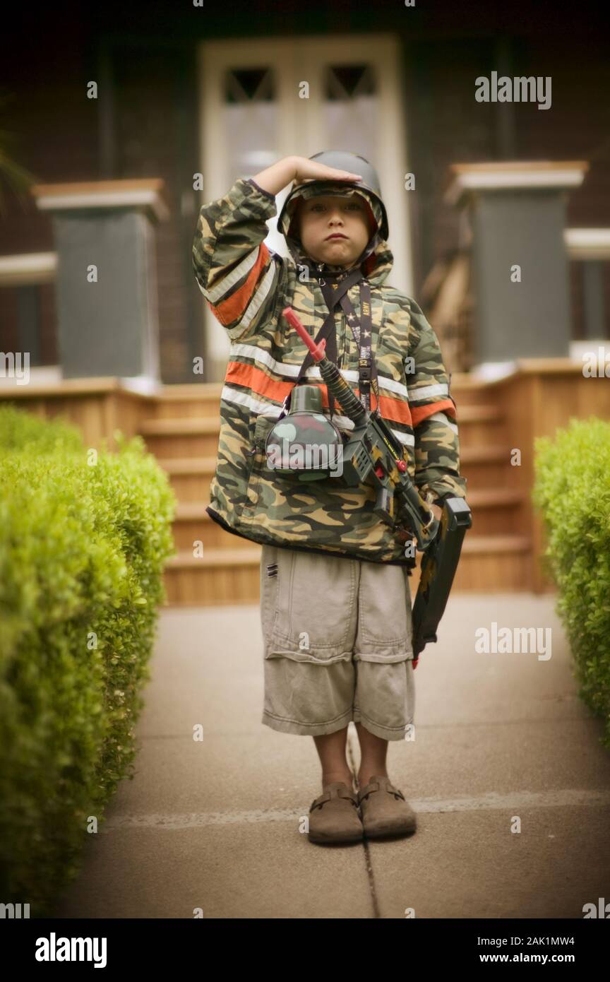 Boy in army gear saluting Stock Photo - Alamy
