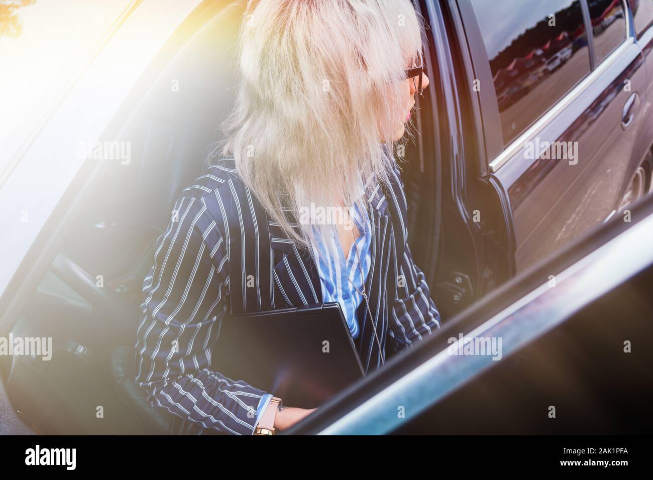 Young beautiful business woman is getting out of the car Stock Photo ...