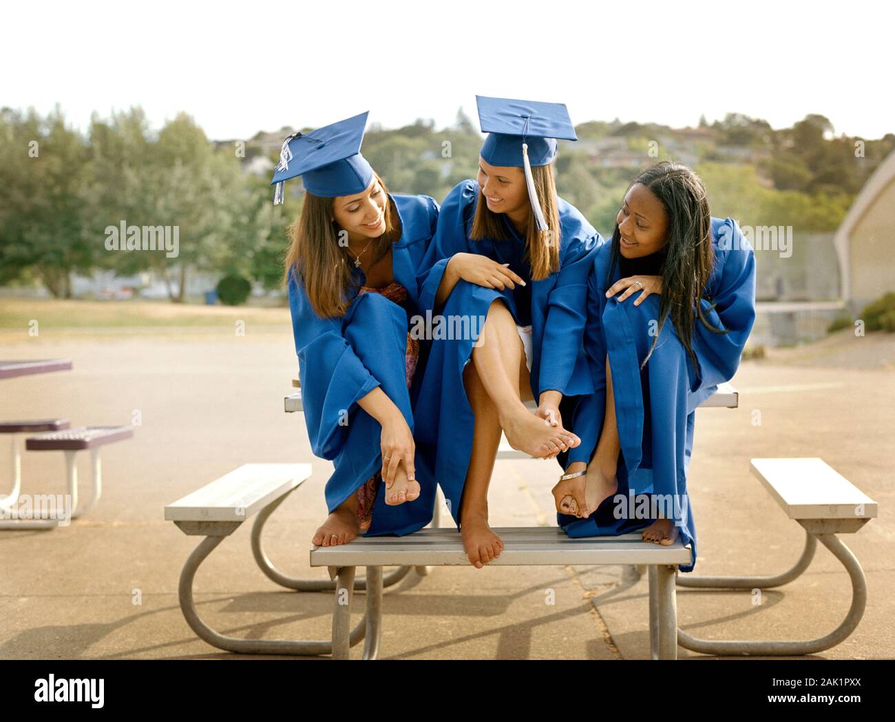 Portrait of three high school girls wearing caps and gowns Stock Photo ...