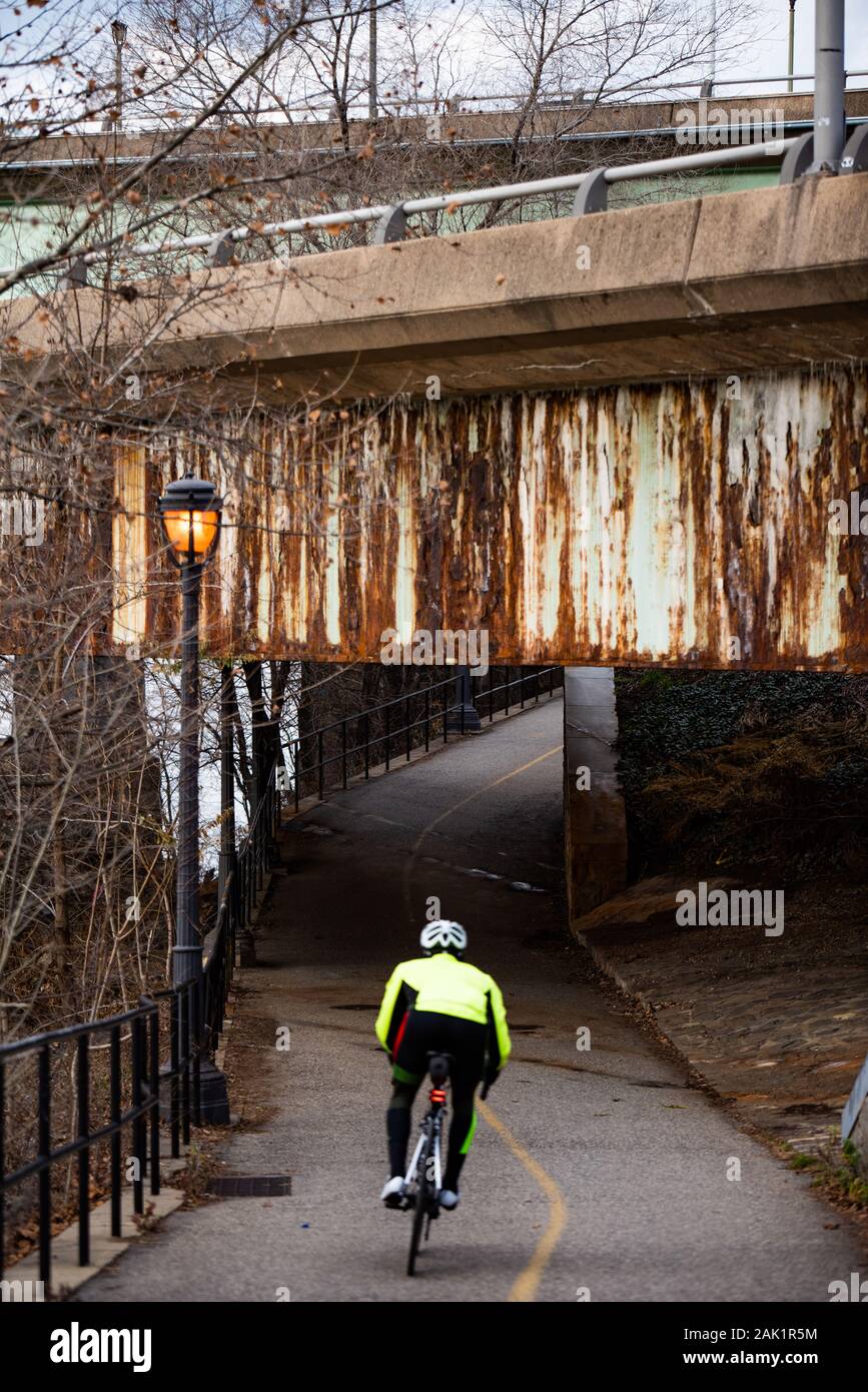 A cyclist weaves his way on a cycle path under two bridges Stock Photo ...