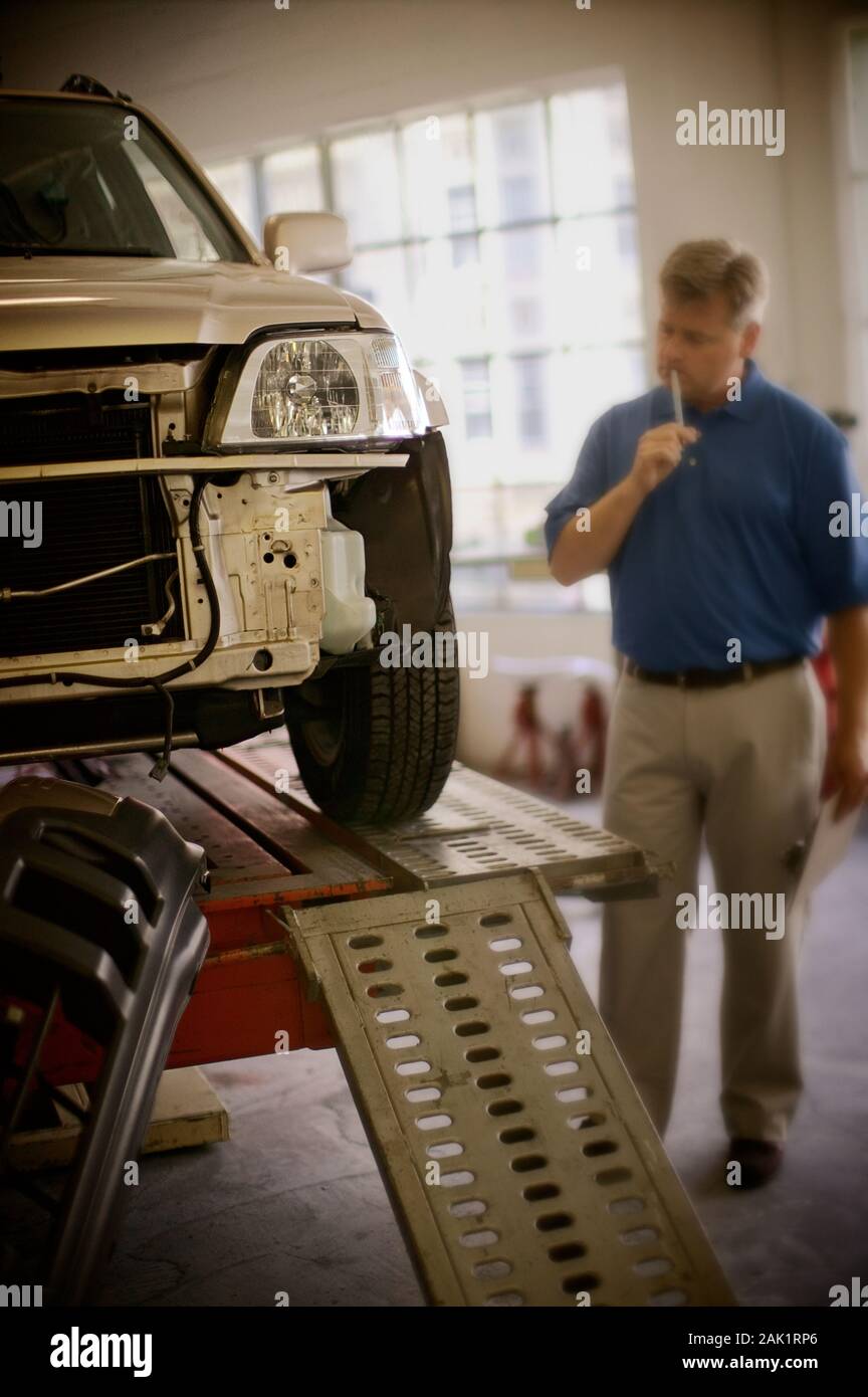 A car mechanic examines the body of a car Stock Photo - Alamy