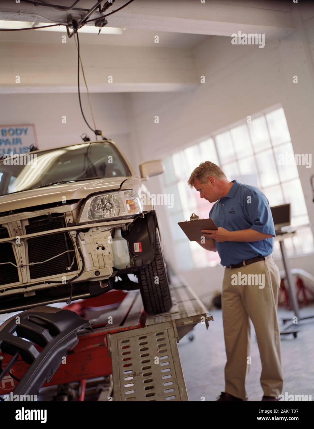 Mechanic conducting a security check on a car elevated inside a ...