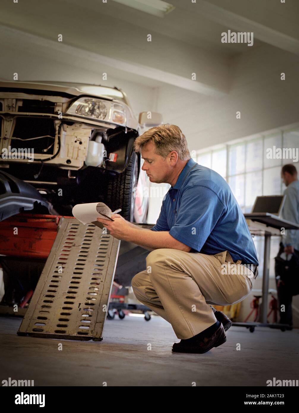 Safety officer inspecting a vehicle inside a workshop Stock Photo - Alamy