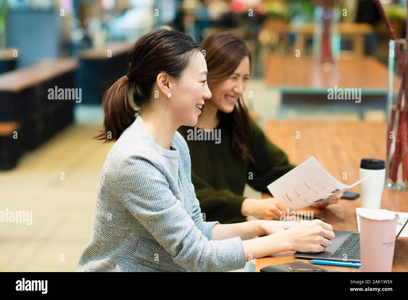 Two women in coworking office Stock Photo - Alamy