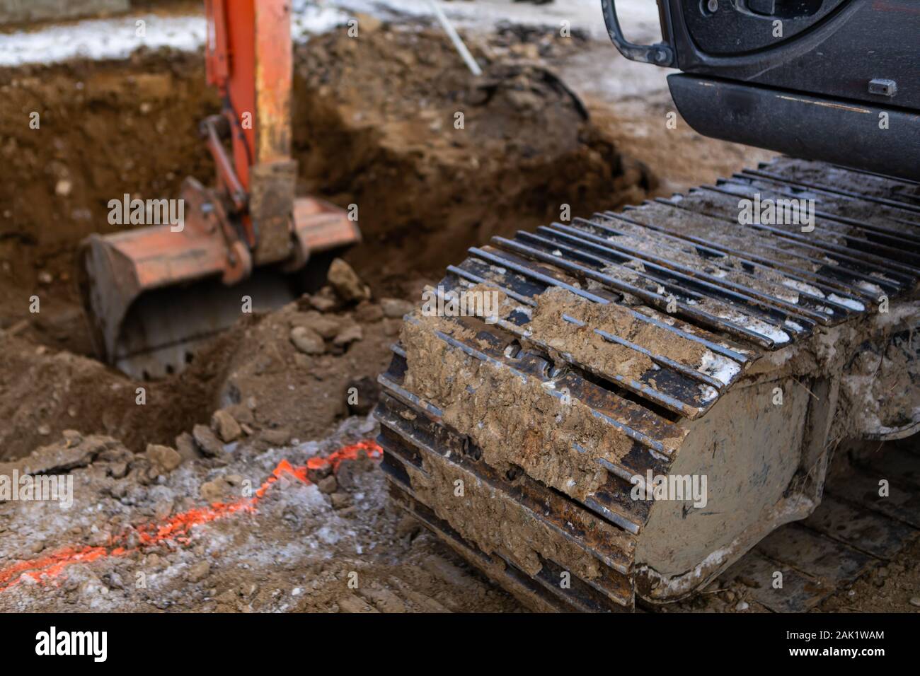 A close up view on the continuous tread of a mini excavator at work on ...