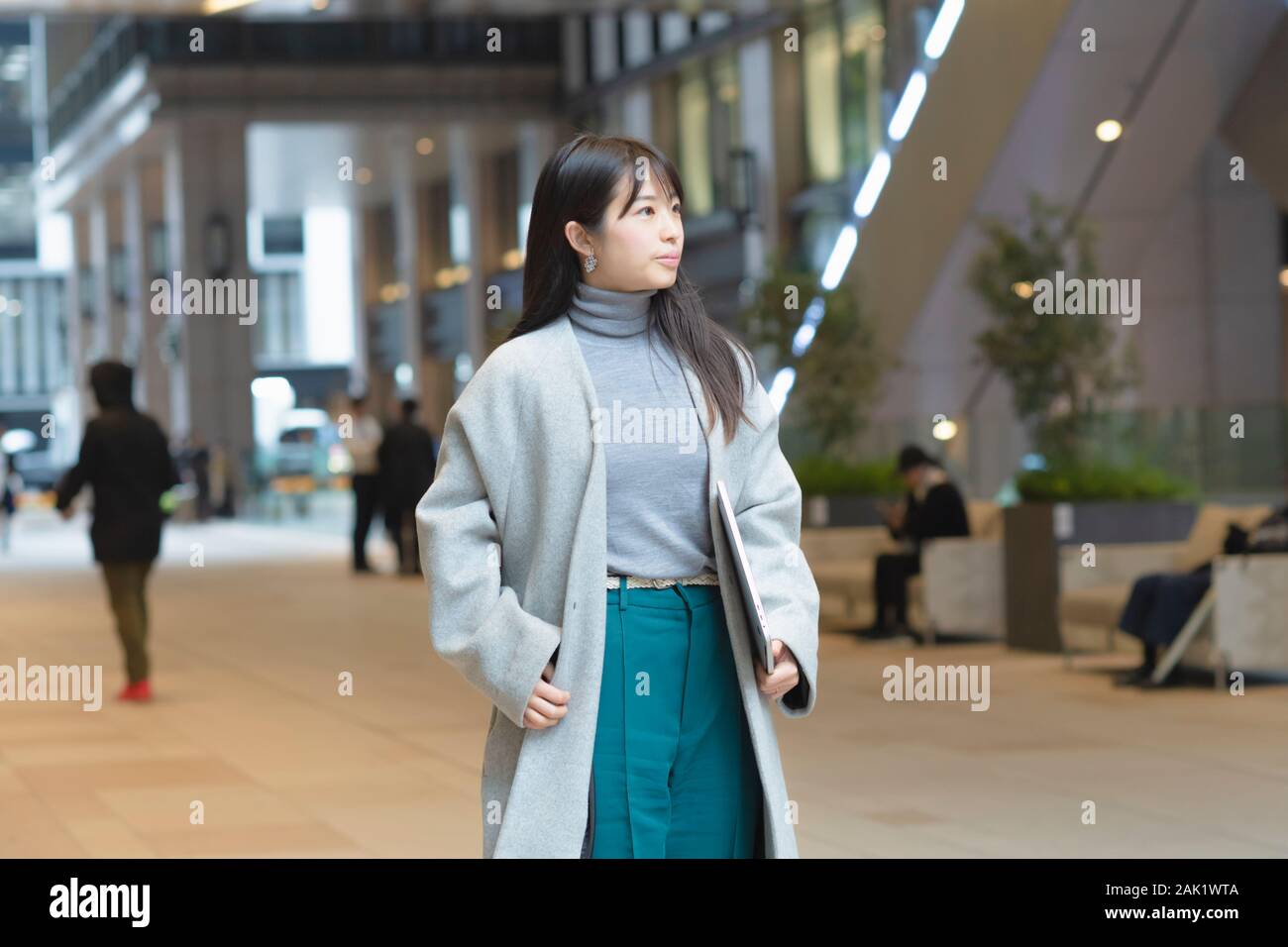 Woman holding laptop under the arm Stock Photo - Alamy