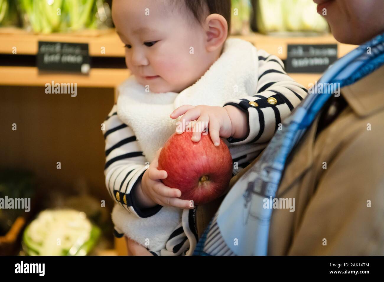 Baby holding apple Stock Photo - Alamy