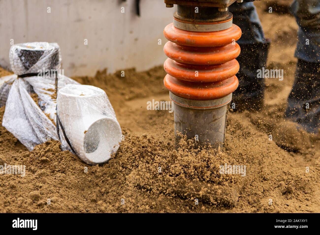 Close up details of a man operating rammer, aka a tamper, at work on a ...