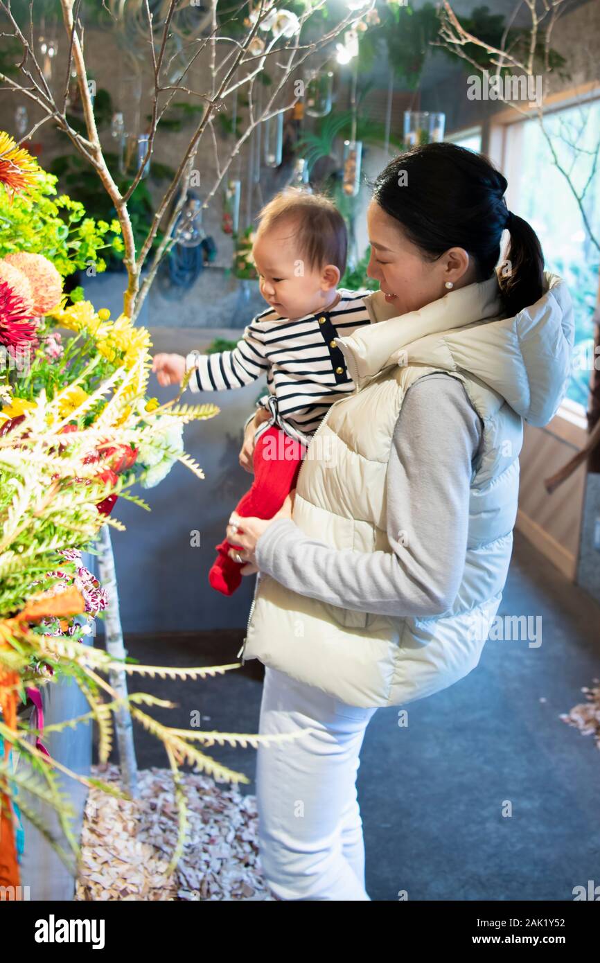 Mother and baby shopping for flowers in flower shop Stock Photo - Alamy