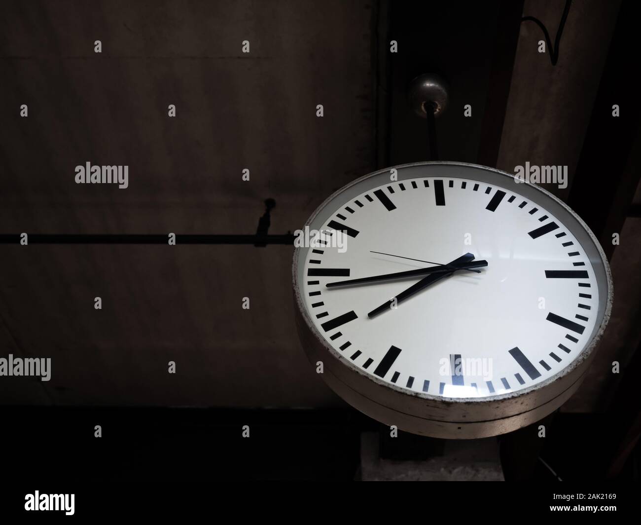 Simple old round clock hanging from wooden ceiling decoration in cafe ...