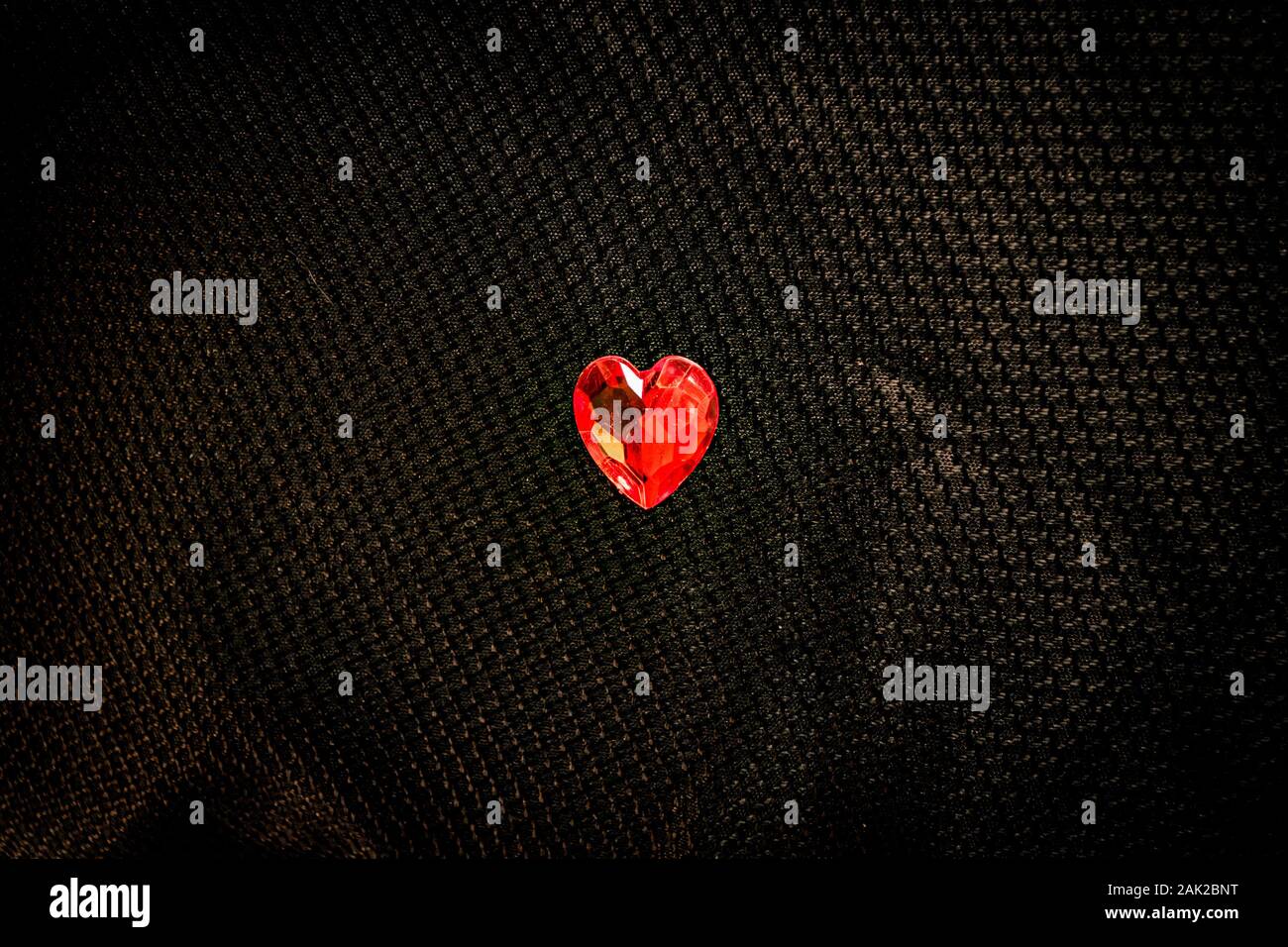 red heart gem stone on black background Stock Photo - Alamy