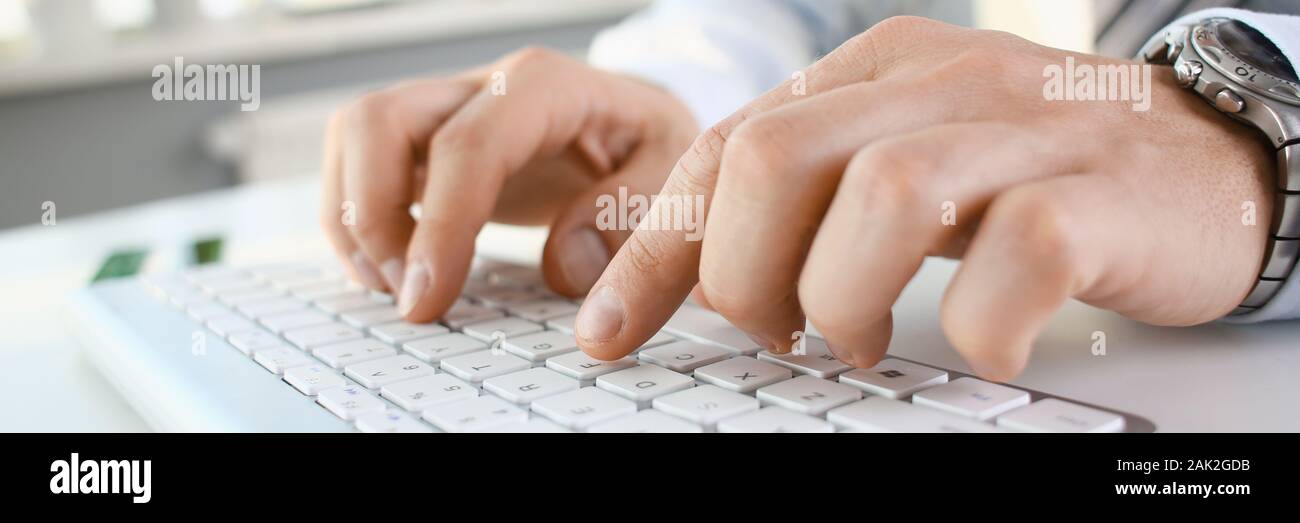 Male arms in suit typing on silver keyboard Stock Photo - Alamy