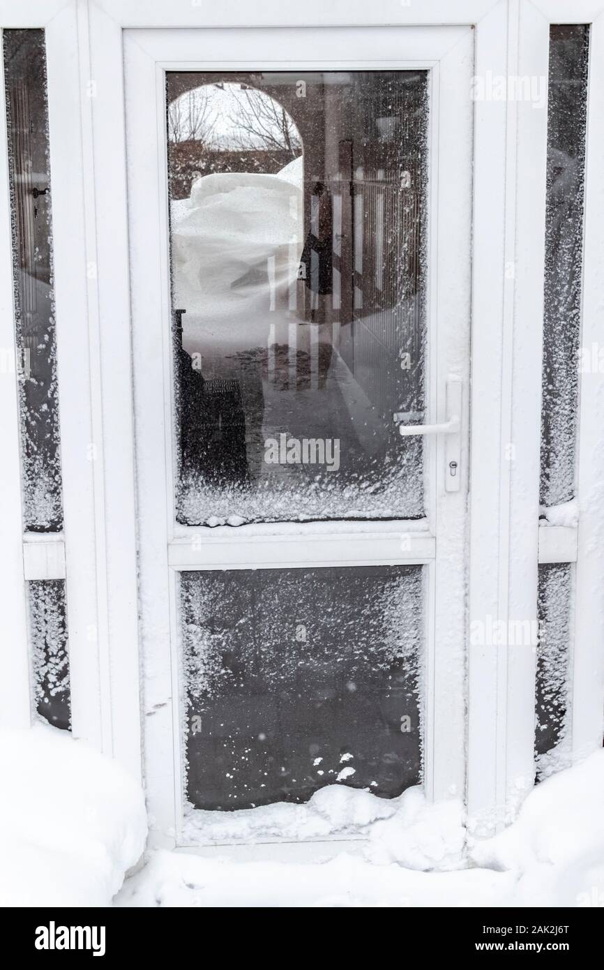 The white front door is covered with snow after a blizzard Stock Photo ...