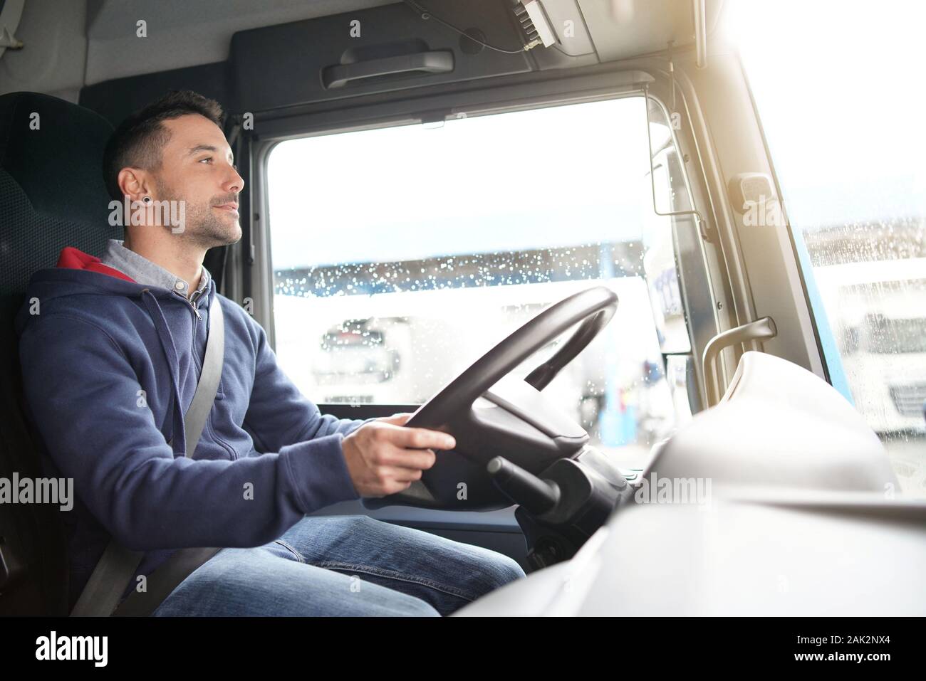 Truck driver at streering wheel Stock Photo - Alamy