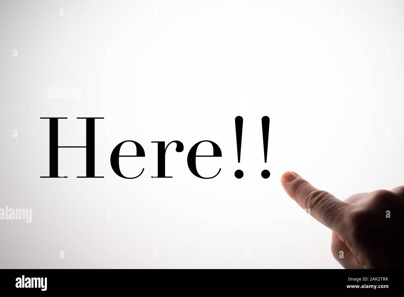 Indication with a finger of the word Here on a backlit surface Stock ...