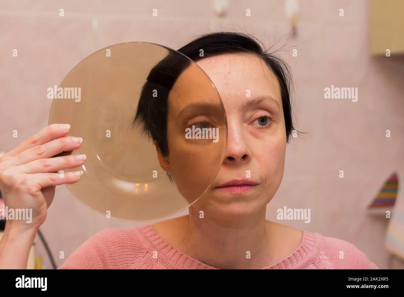 A woman holds a translucent kitchen plate in front of her face Stock ...