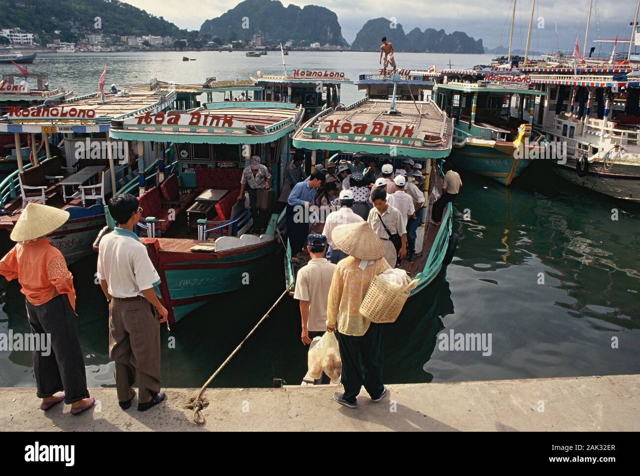Excursion boats anchoring at the coast of the picturesque Ha Long Bay ...
