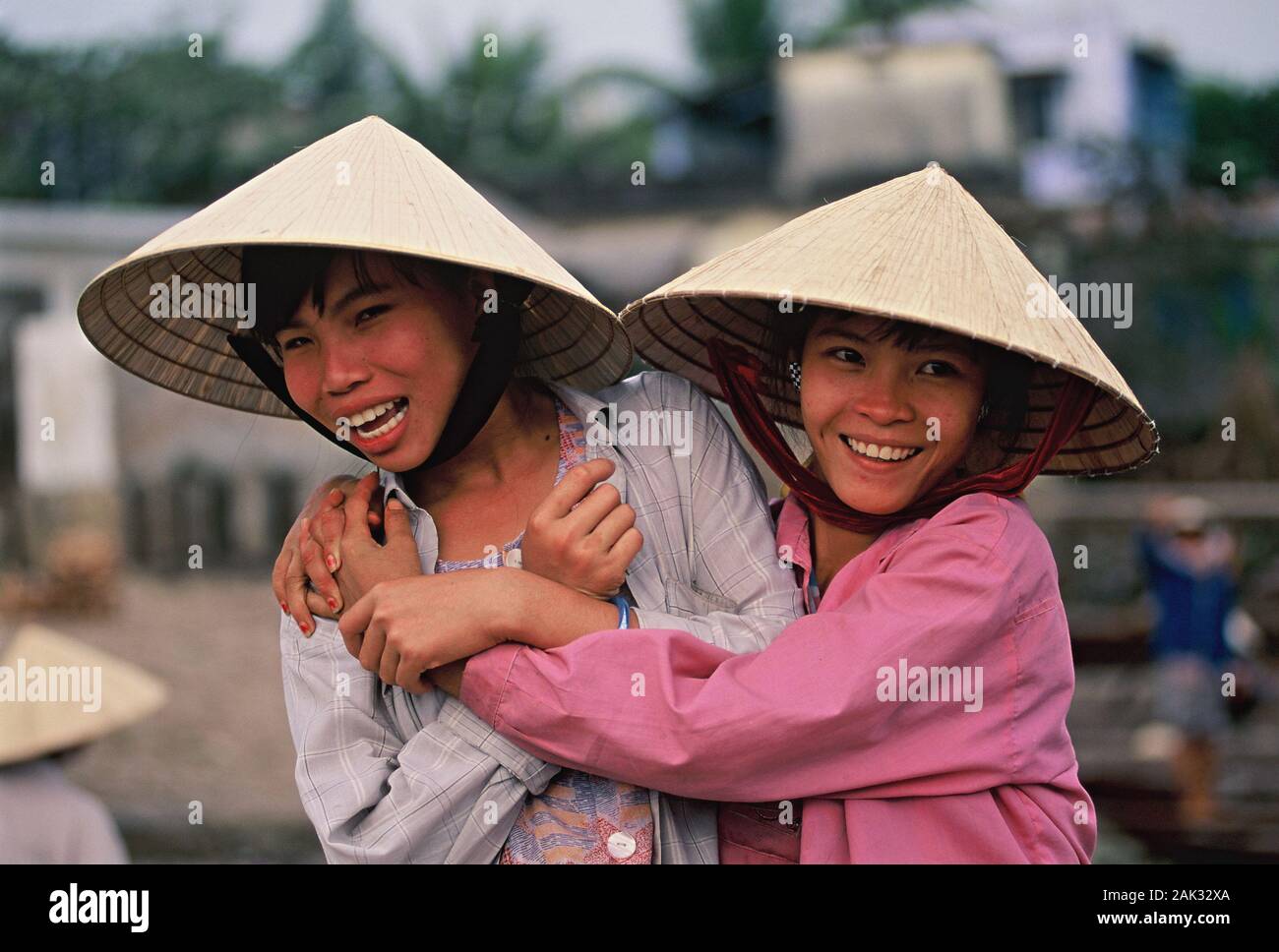 Two Vietnamese girls posing in Hoi An in Central Vietnam in a cheerful ...