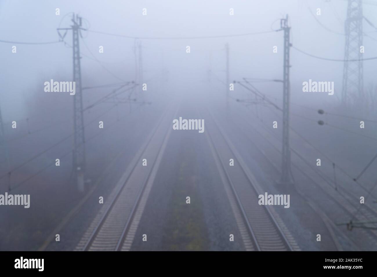 Train tracks in the fog - symmetrical fog image Stock Photo - Alamy