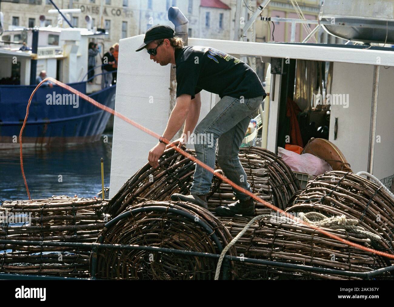 A fisherman is checking the crayfish baskets in the port of Hobart in ...