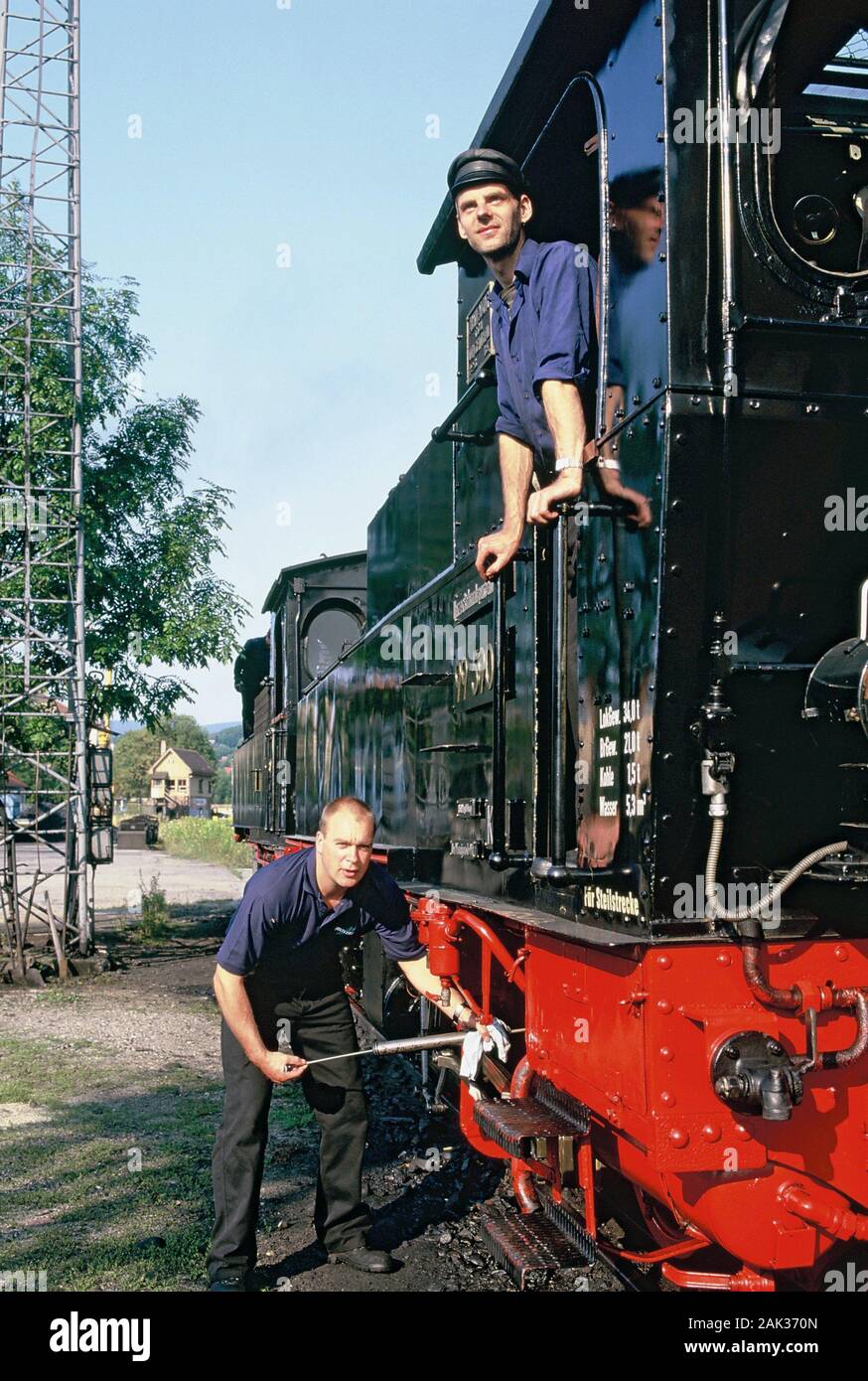 Two railway employees maintaining the locomotive of the historic ...