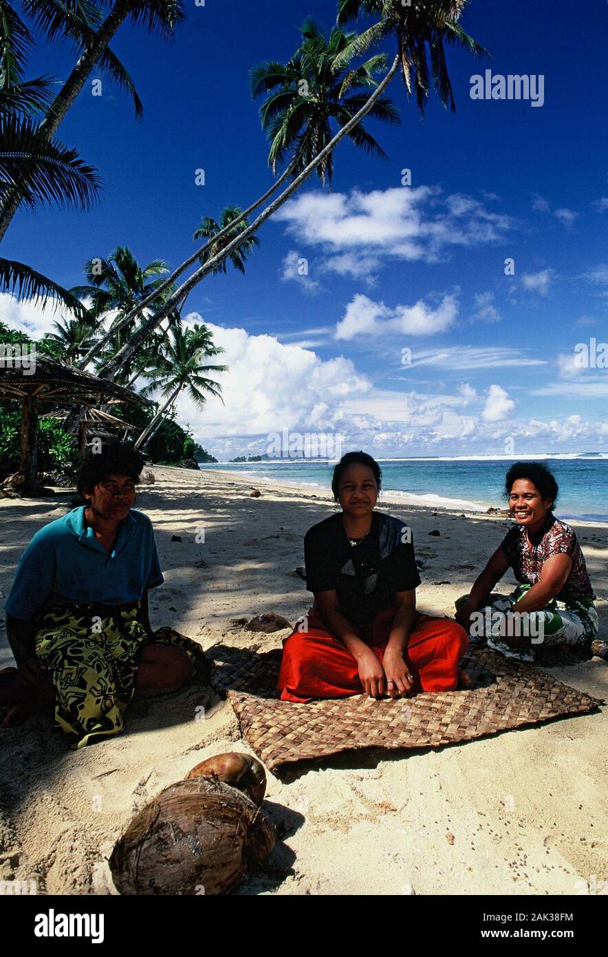 Locals sitting at a beach on an island of the Samoa Archipelago. The ...