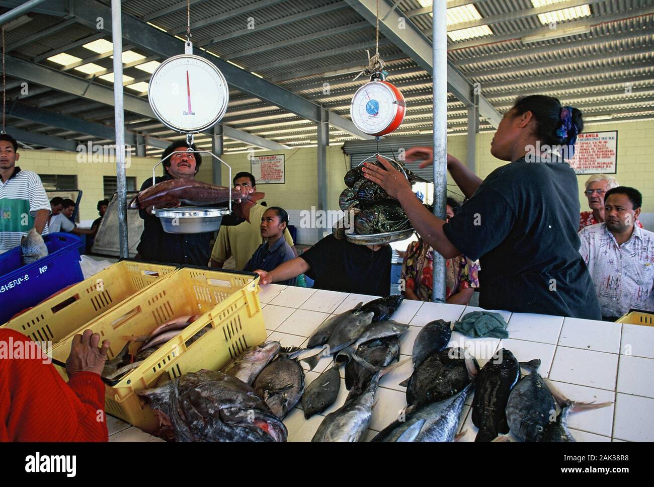 A vendor weighing out fishes in the seafood market hall of Nuku'alofa ...