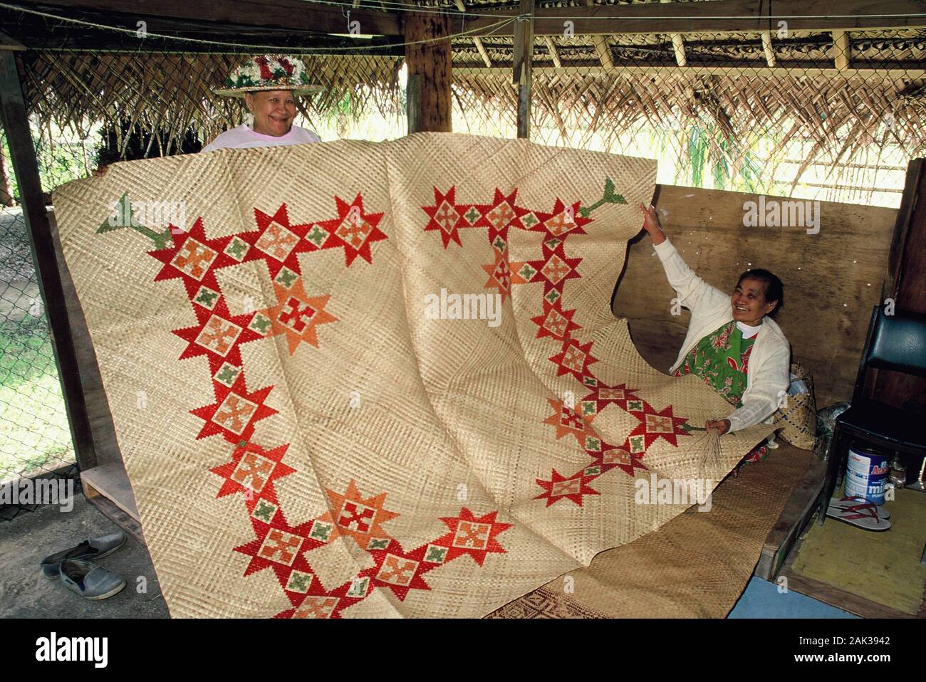 Two local women showing a hand-made pandan mat in the Women Handicraft ...