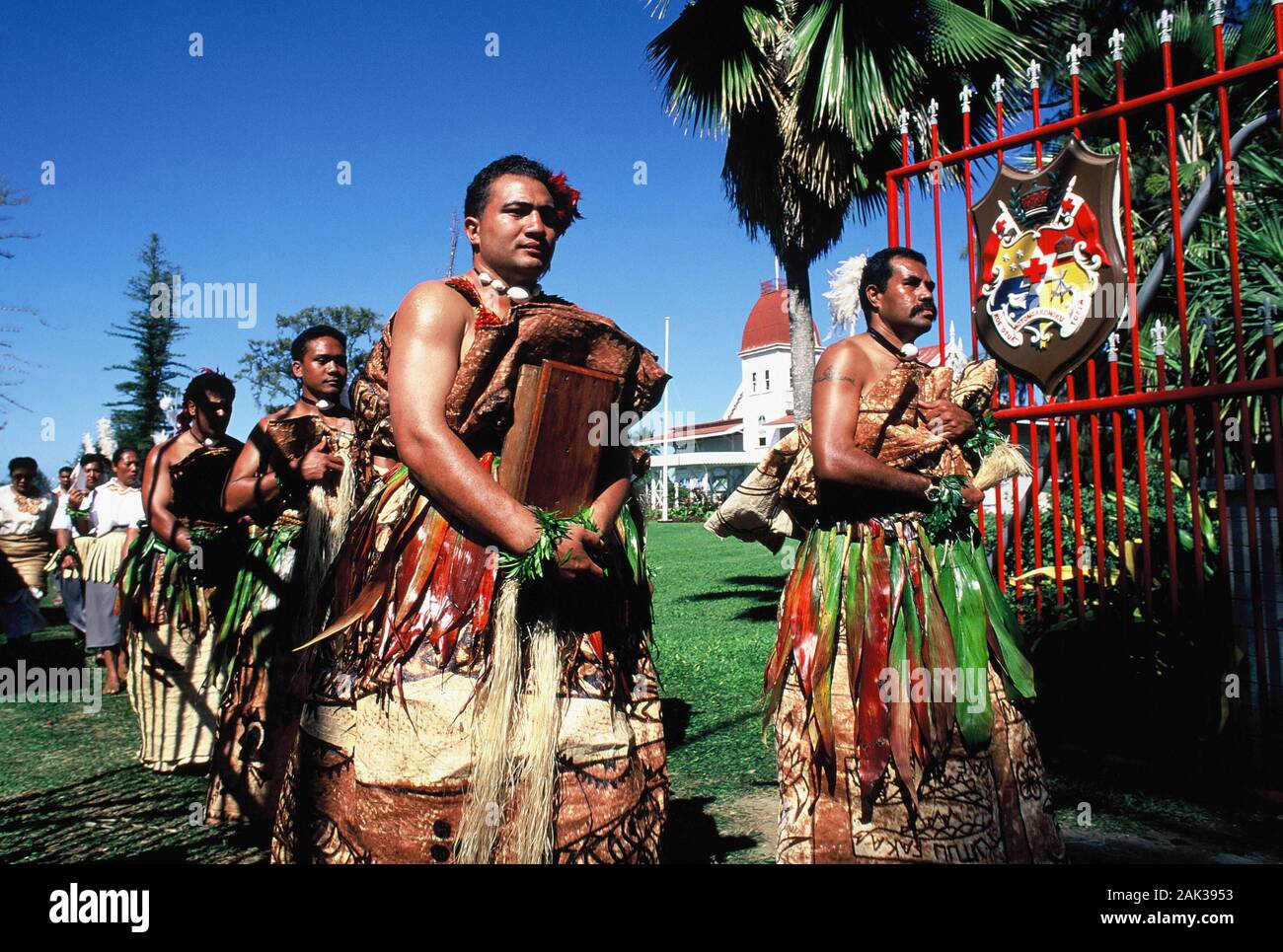 Local dancers dressed in traditional costumes are passing the palace of ...