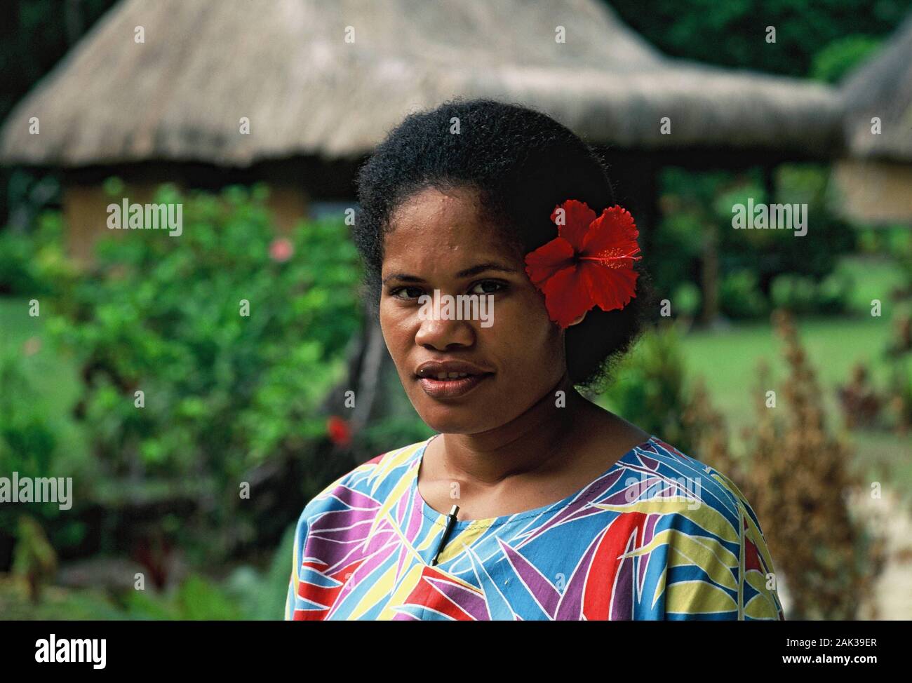 A Fijian woman has decorated her hair with a red flower. Taveuni is the ...