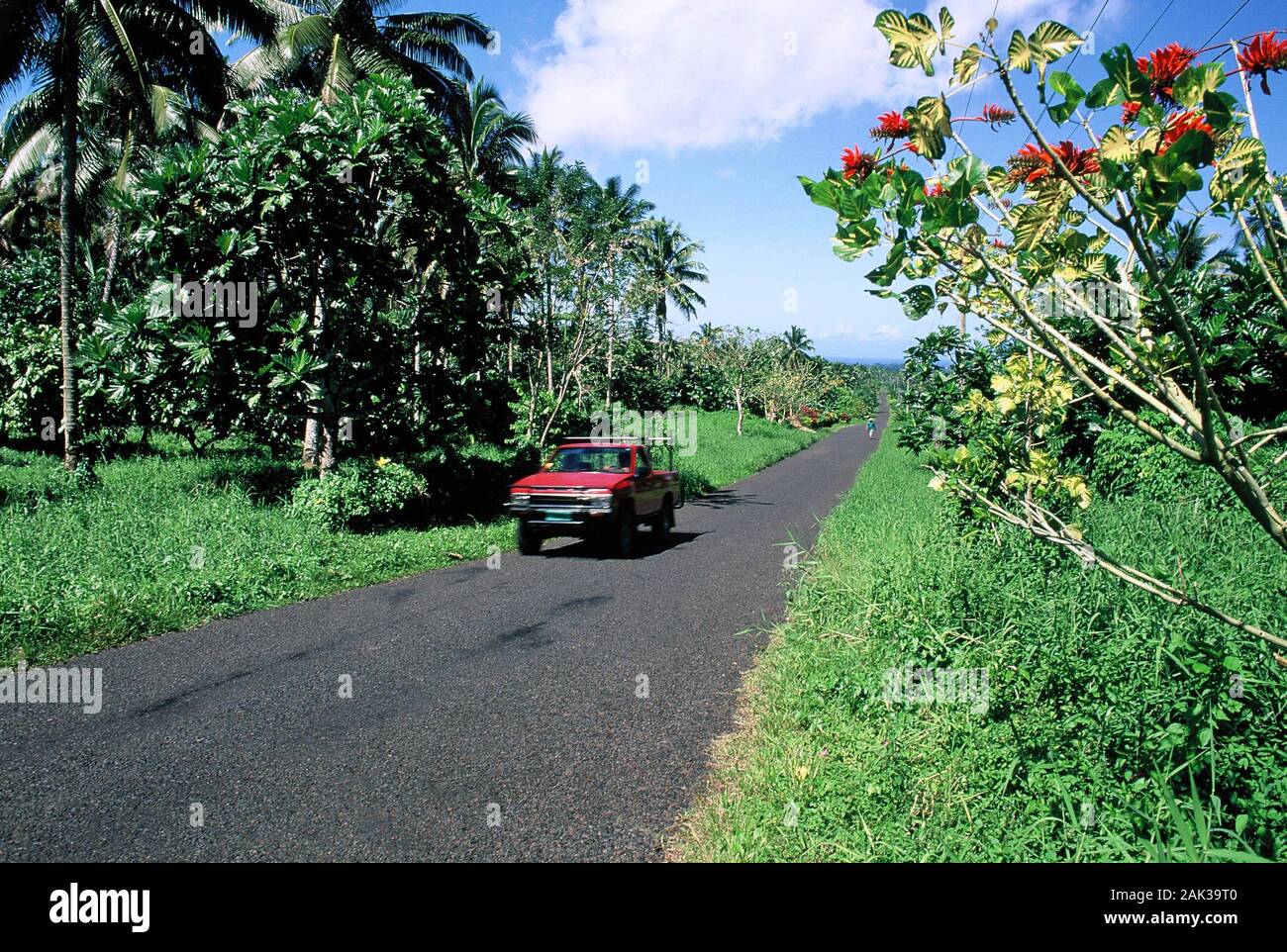 A rover vehicle drives on the Cross Island Road on the island of Upolu ...